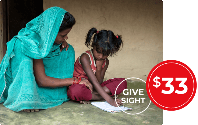 Bandana and her mom sitting on the ground in Nepal.